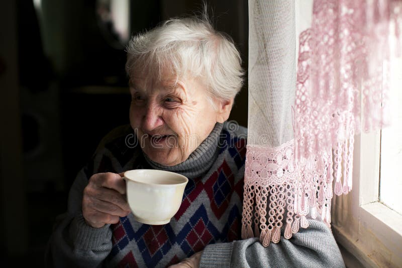 An Elderly Woman Laughs and Drinks Tea at the Table Stock Image - Image ...