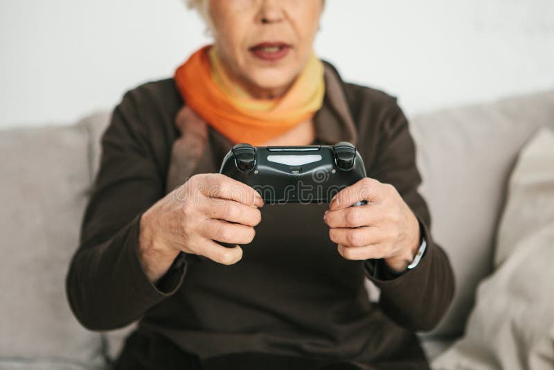 An Elderly Woman is Playing a Video Game. Elderly Person and Modern ...