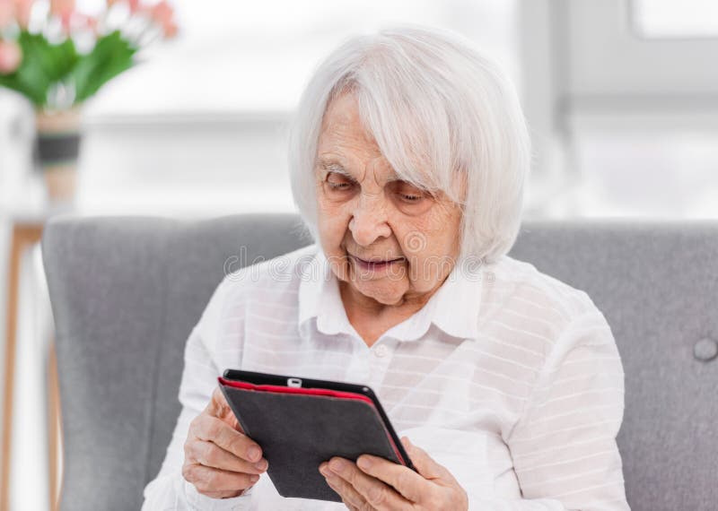 Elderly woman with tablet stock photo. Image of connection - 222509508