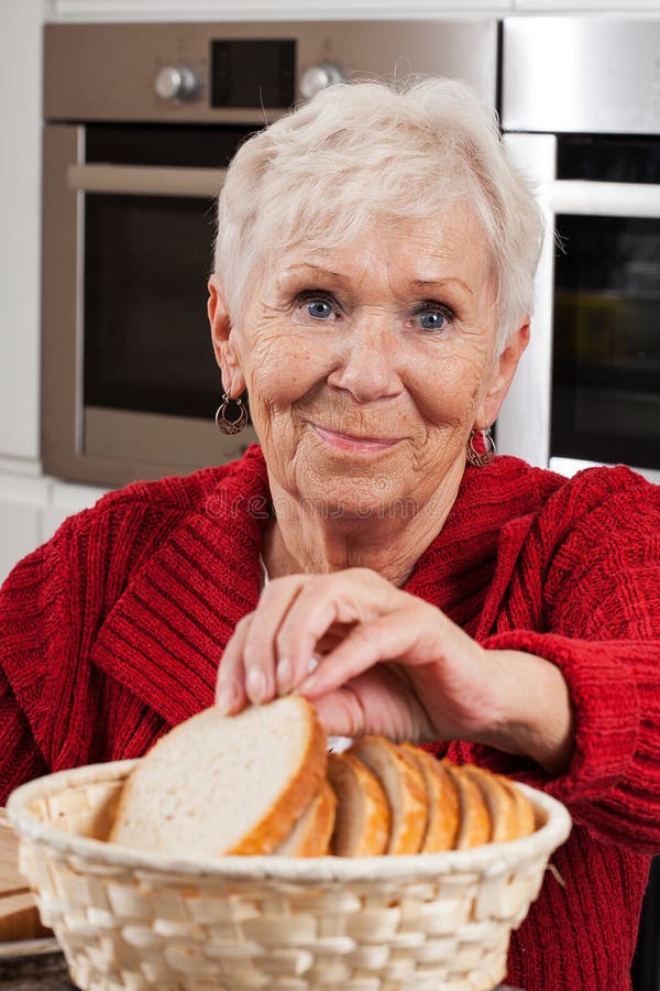 Elderly woman taking bread stock image. Image of interior - 39924557