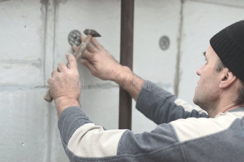 An Elderly Workman Clogs a Dowel into a Plastic Umbrella Mount in a ...