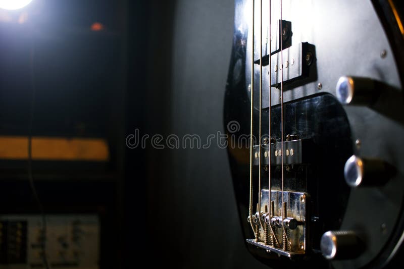 An Electric Bass Guitar Hanging on a Black Wall Stock Image - Image of ...