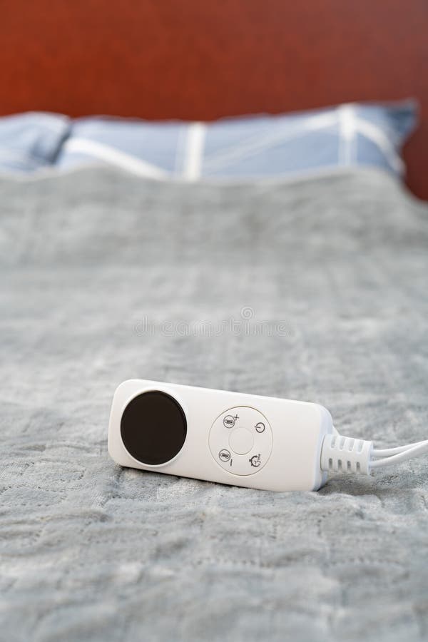 An Electric Blanket with Controller on a Bed at Vertical Composition ...