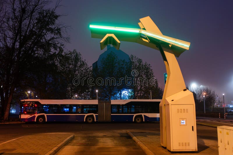 An Electric Bus Stands at an Empty Bus Stop and Charges, a Close Up ...