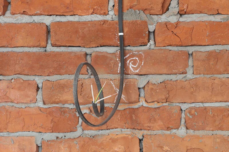 An Electric Cable is Installed on the Brick Wall of a New House Under ...