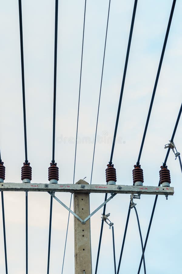 Electric Cable is Stretched Over Cement Poles Against a Light Sky ...