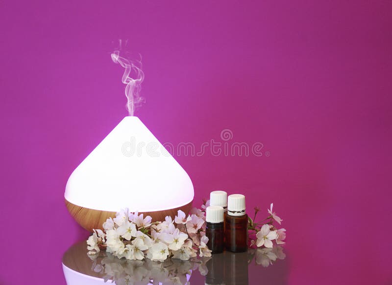 Electric Essential Oils Aroma Diffuser, Oil Bottles and Flowers Stock ...