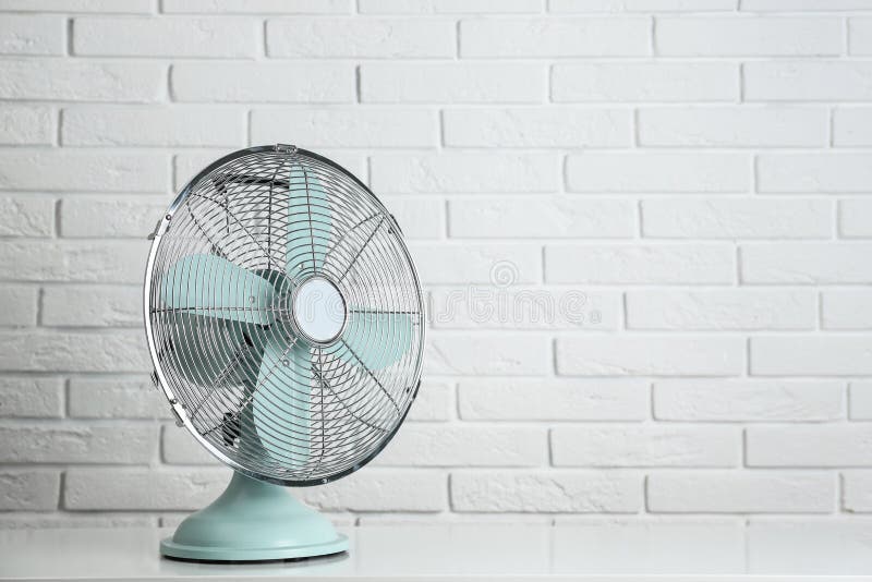 Electric Fan on Table Near White Brick Wall, Space for Text. Summer ...