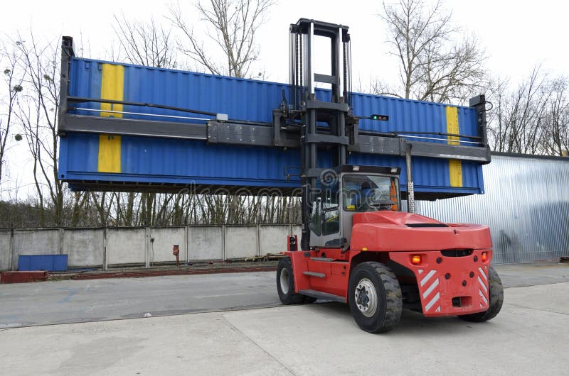 Electric Forklift Loader Carrying Cargo Container in a Container Yard ...