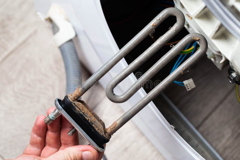 Electric Heating Element in Hand Against the Background of a Washing ...