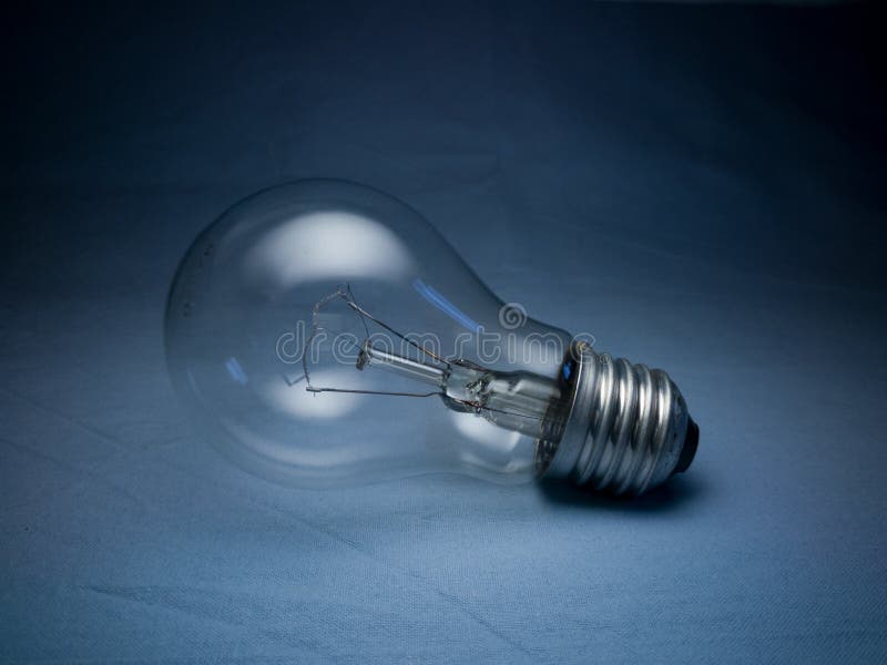 Electric Light Bulb on a Blue Textile Background in the Dark Stock ...