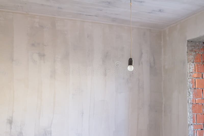 An Electric Light Bulb Hangs on a Long Electrical Cable on the Ceiling ...