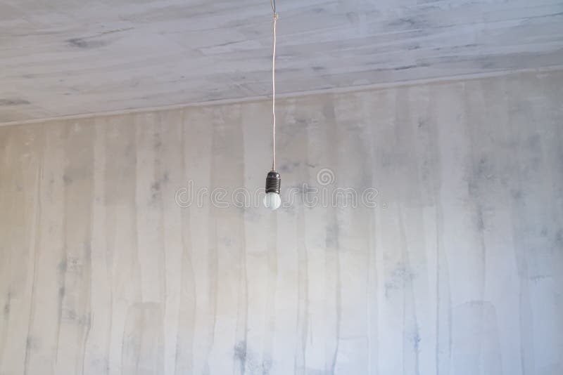 An Electric Light Bulb Hangs on a Long Electrical Cable on the Ceiling ...