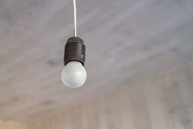 An Electric Light Bulb Hangs on a Long Electrical Cable on the Ceiling ...