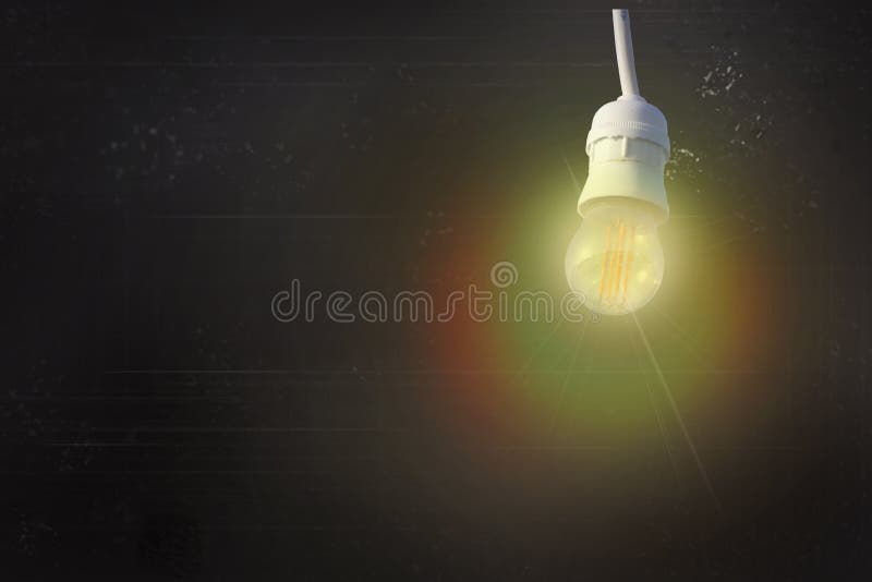 An Electric Light Bulb Shines with a Dim Light on a Gray Background ...