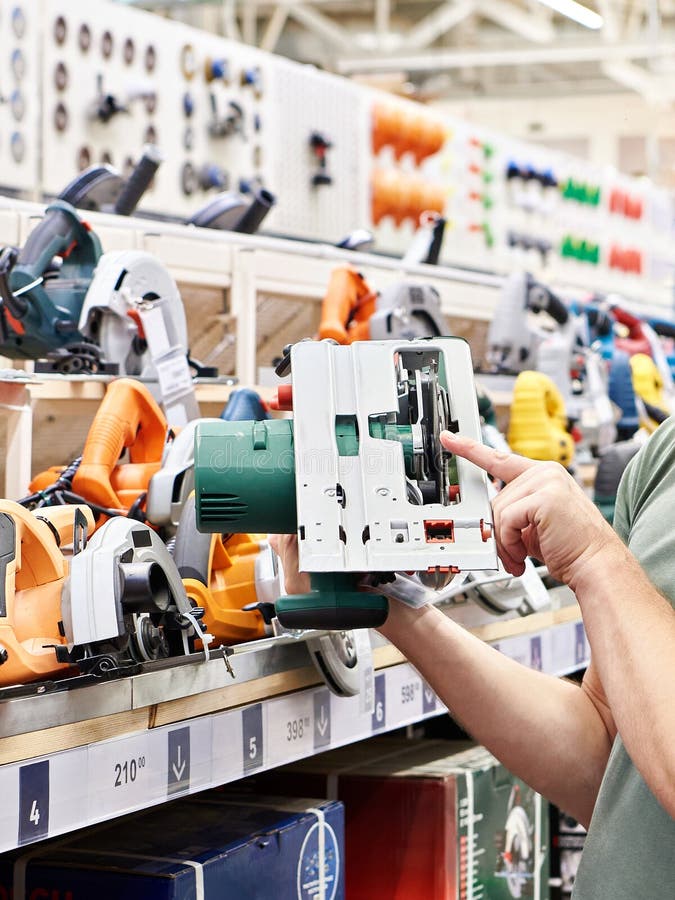 Electric saw in hands stock photo. Image of purchase - 265680570