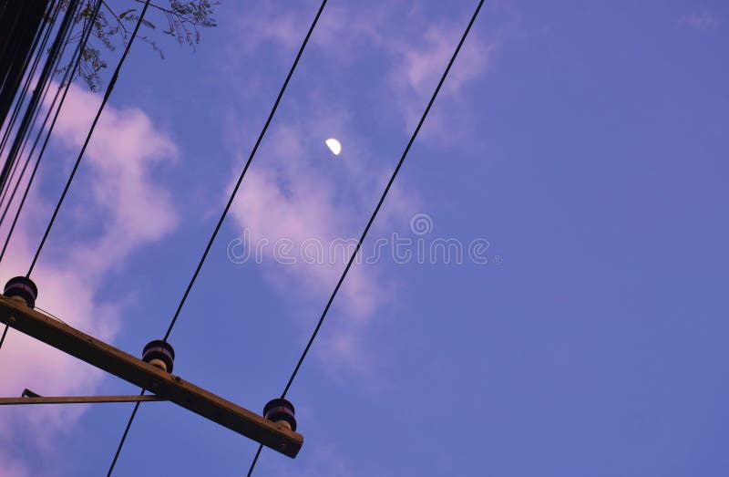 Electric Pole and Cable Line with Half Moon Background in Blue Evening ...