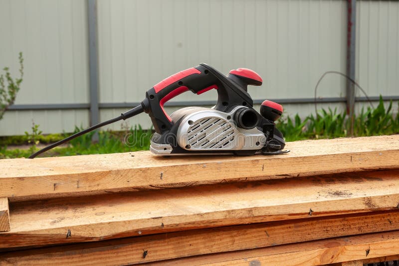 An Electric Power Planer Sits on Wood Planks, Ready for a Woodworking ...