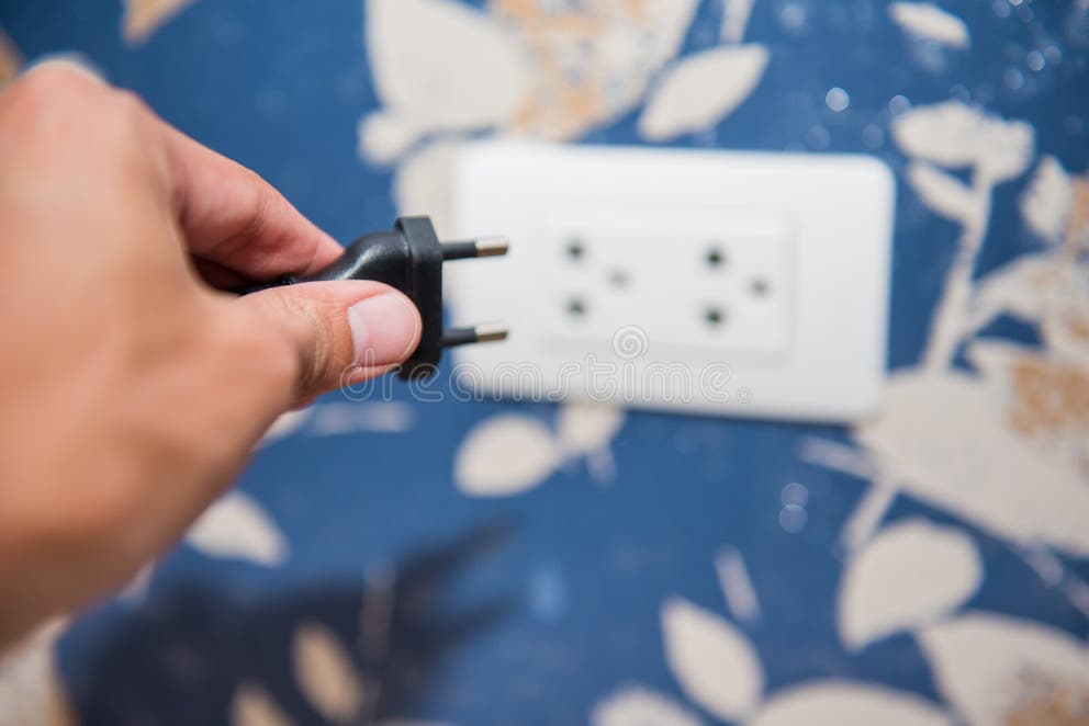 Electric Power Plug in a Hand and Inserting into Power Wall Socket ...