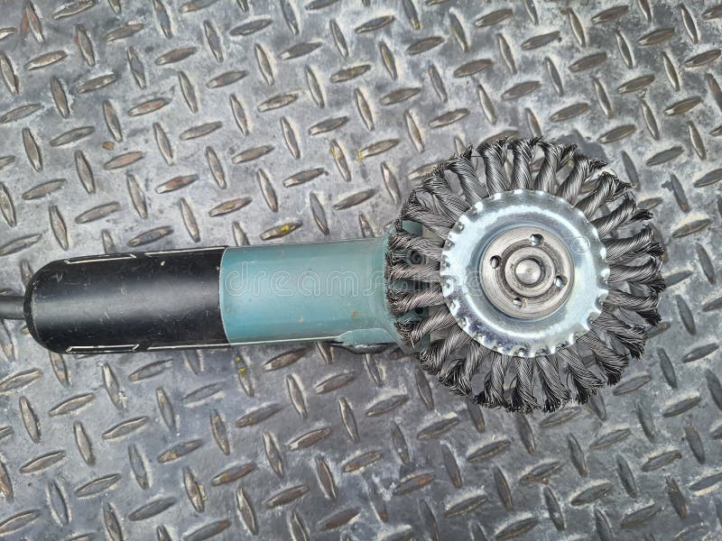 Electric Rotating Wire Brush Grinder on a Metal Floor. Stock Photo ...