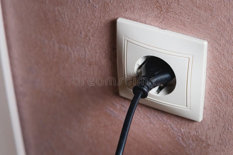 Electric Socket on a Pink Wall. the Black Wire Plug is Connected ...