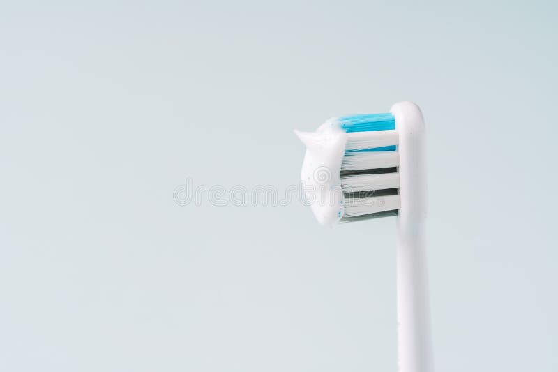 Electric Toothbrush Head with Toothpaste Against Blue Background Stock ...