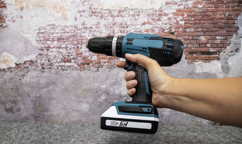 Electric Turquoise Power Drill in Hand Against a Brick Wall Stock Image ...