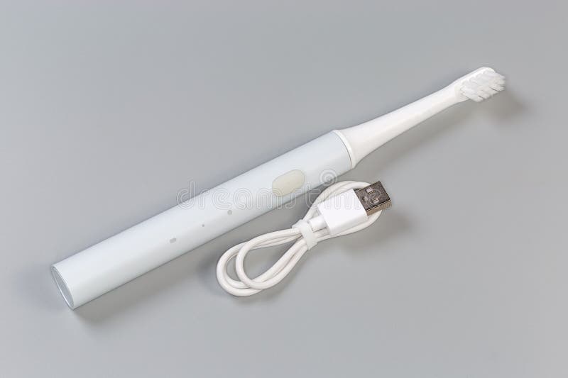 Electric Ultrasonic Rechargeable Toothbrush and Charging Cable on Gray ...