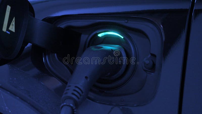 Electric Vehicle or EV Car Charging at a Station. with a Glowing Light ...