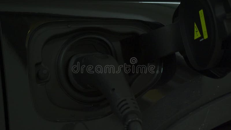 Electric Vehicle or EV Car Charging at a Station. with a Glowing Light ...