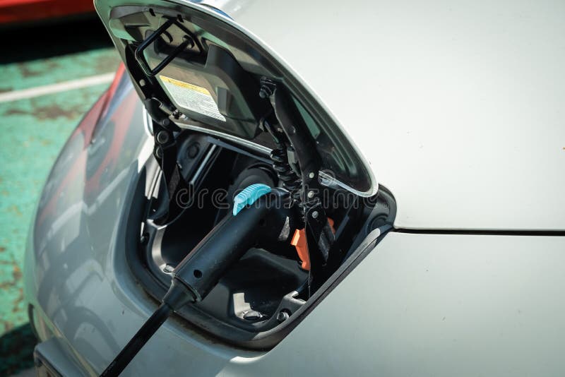 Electric Vehicle with a Front Charging Port Plugged in and Charging the ...