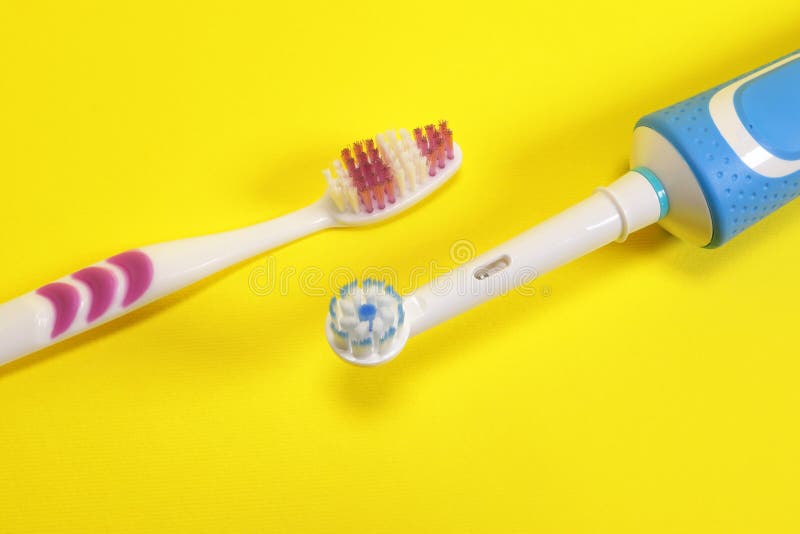 Electric Vs Manual Toothbrushes on Yellow Background Stock Photo ...