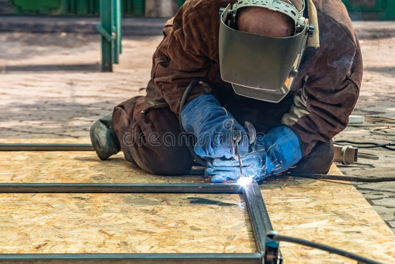 An Electric Welder Assembles a Metal Structure from a Shaped Pipe by ...