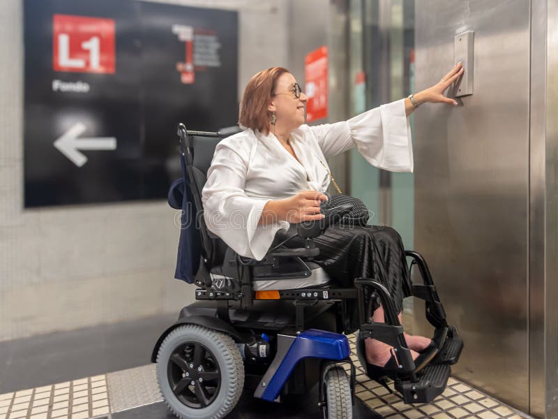 Electric Wheelchair User Pressing Elevator Button in Metro Stock Photo ...