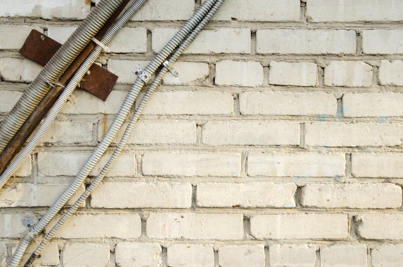 Electric Wires in a Protective Pipe on a Brick Wall Stock Photo - Image ...