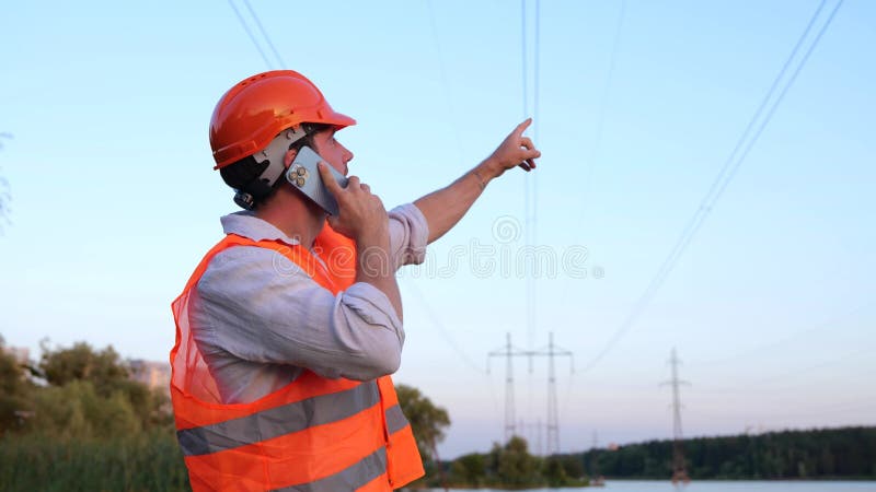 Electrical Engineer in Helmet Checking Power Line while Talking on the ...