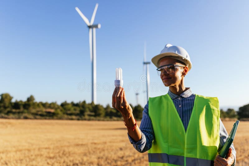 Electrical Engineer Holding Energy Saving Light Bulb on Unfocused ...