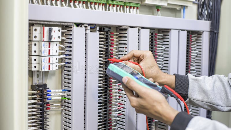 An Electrical Engineer is Investigating an Electrical Control Cabinet ...