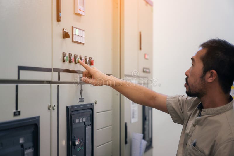 Electrical Engineer Man Checking Voltage and Test at the Power ...