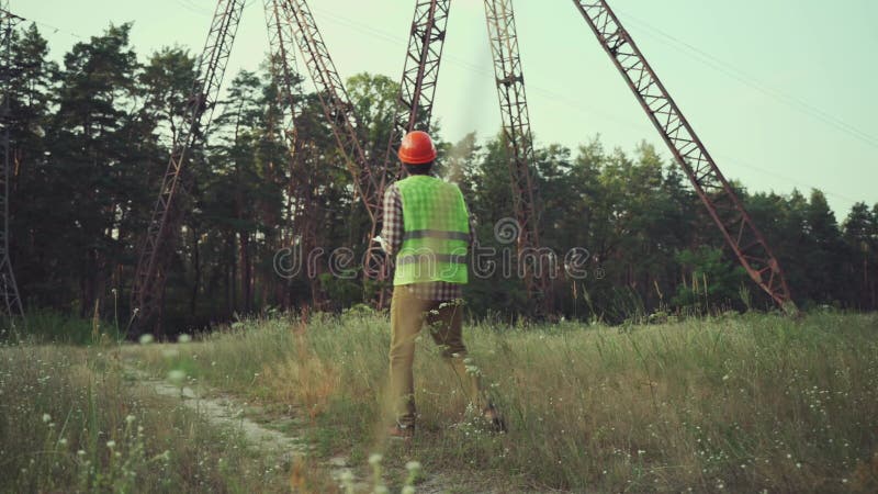 Electrical Engineer Near High Voltage Tower with Clipboard and ...
