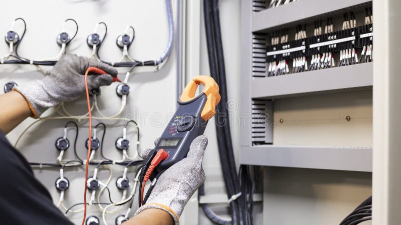 Electrical Engineer Tests the Operation of the Electric Control Cabinet ...