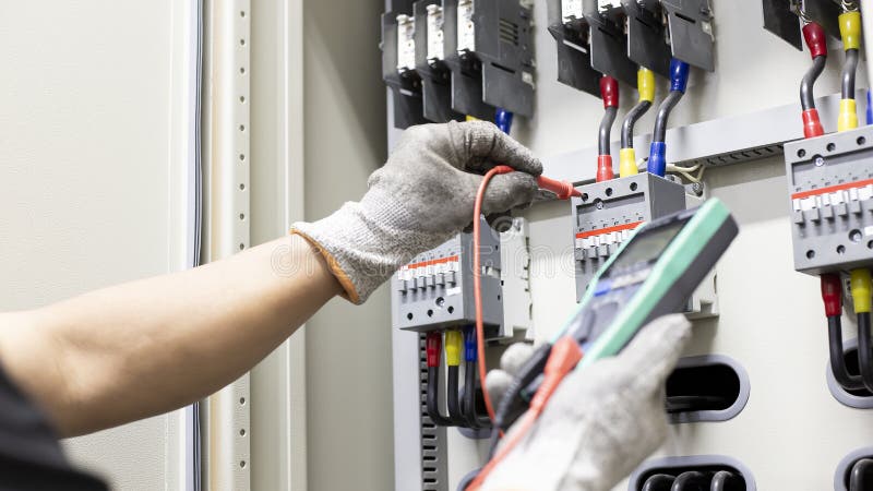 Electrical Engineer Tests the Operation of the Electric Control Cabinet ...