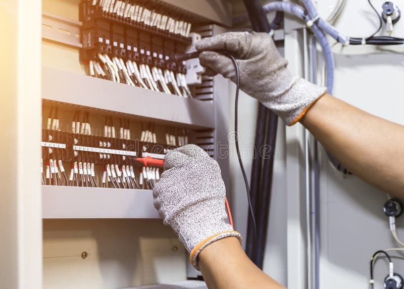 An Electrical Engineer is Investigating an Electrical Control Cabinet ...