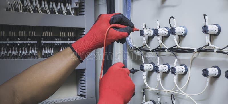 Electrical Engineer Tests the Operation of the Electric Control Cabinet ...