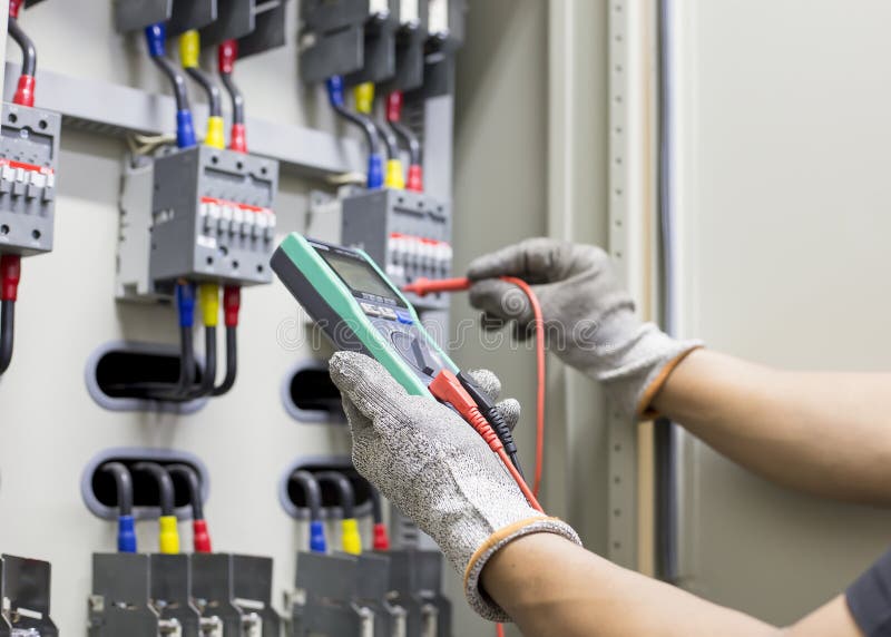 Electrical Engineer Tests the Operation of the Electric Control Cabinet ...