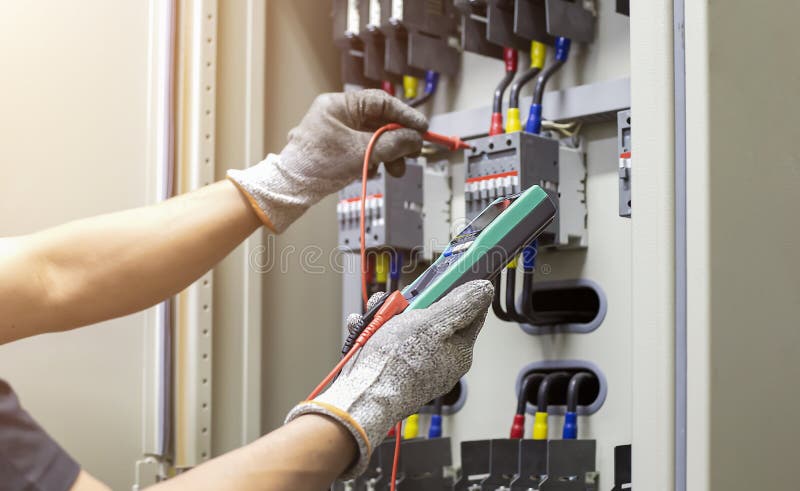 Electrical Engineer Tests the Operation of the Electric Control Cabinet ...
