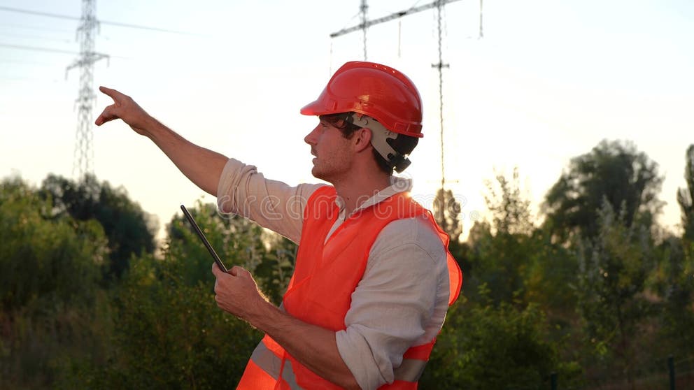 Smiling Young Electrical Engineer Standing Outdoors while Holding ...