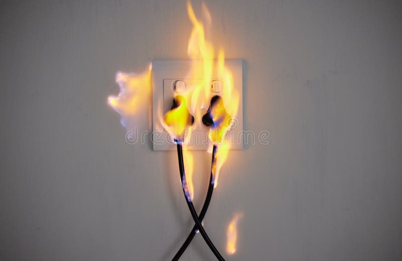 Electrical Fire. Two Plugs in a Wall Socket Catching Fire. Stock Image ...