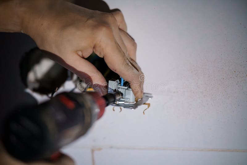 Electrical Installation: a Close-Up of Hands Installing a Wall Outlet ...