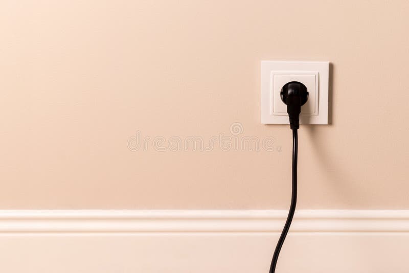 Electrical Outlet with Plug on Beige Wall Stock Photo - Image of ...